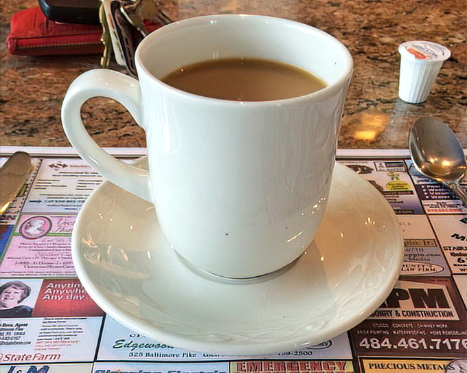 Coffee served on a placemat of local ads – the quintessential diner experience where your caffeine comes with community connections.