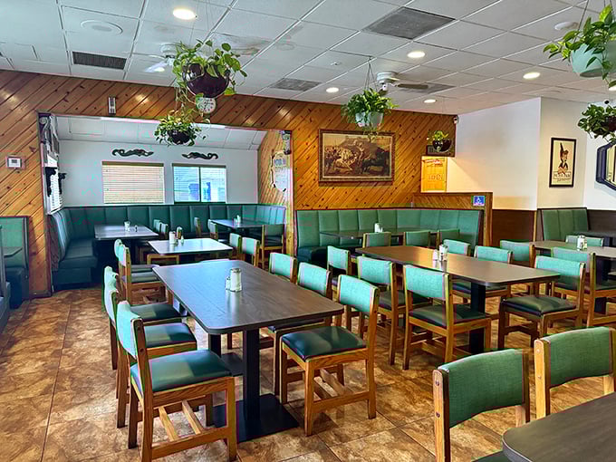 The green booth section – where family gatherings happen and diet plans go to die. Those wooden chairs have supported generations of satisfied diners.