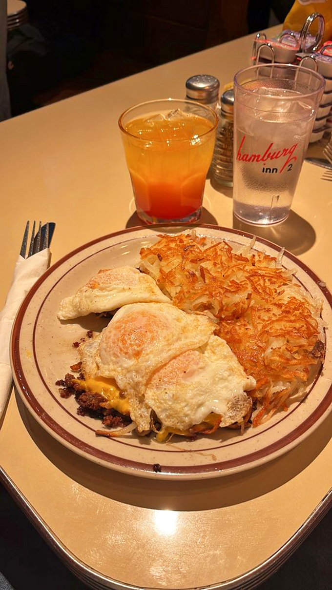 Eggs, hash browns, and what appears to be a Tequila Sunrise – proof that breakfast cocktails and diner food create the perfect weekend symphony. The ultimate hangover cure or vacation indulgence.