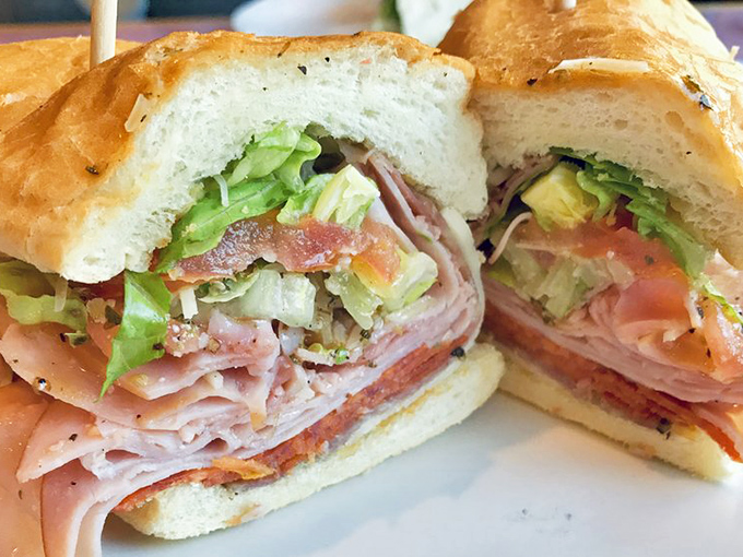 The Italian Cold Cut Sub—a masterclass in sandwich architecture. Each layer visible in perfect cross-section, like a delicious geological formation of meats and veggies.