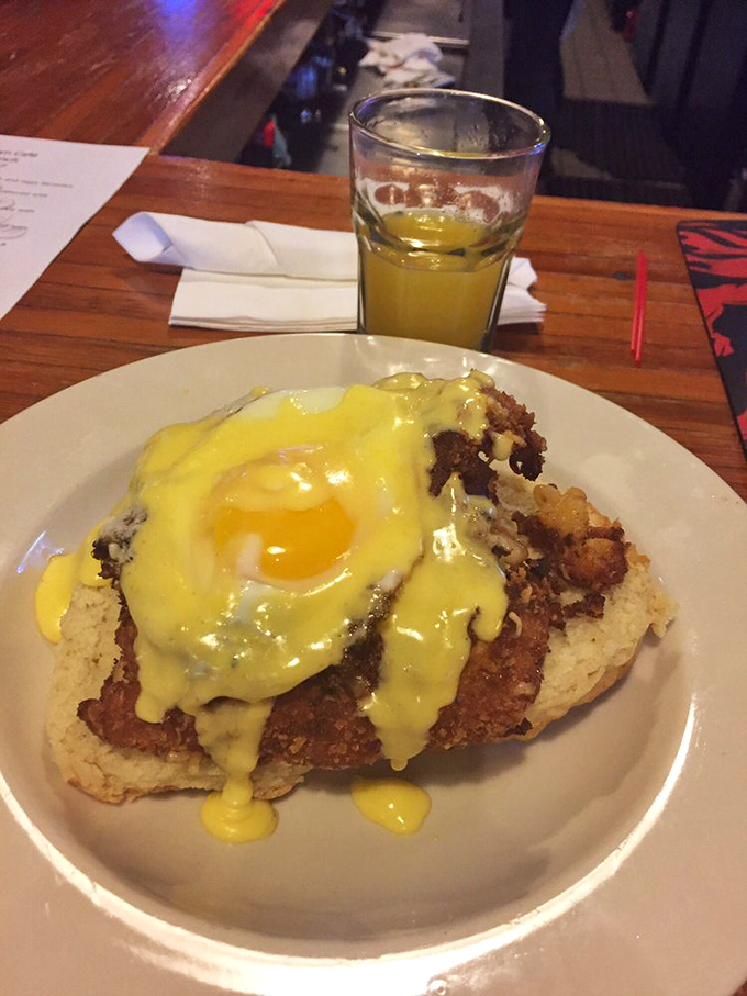 Hollandaise sauce cascading over a perfectly poached egg atop what appears to be a delicious biscuit – breakfast elevated to an art form.
