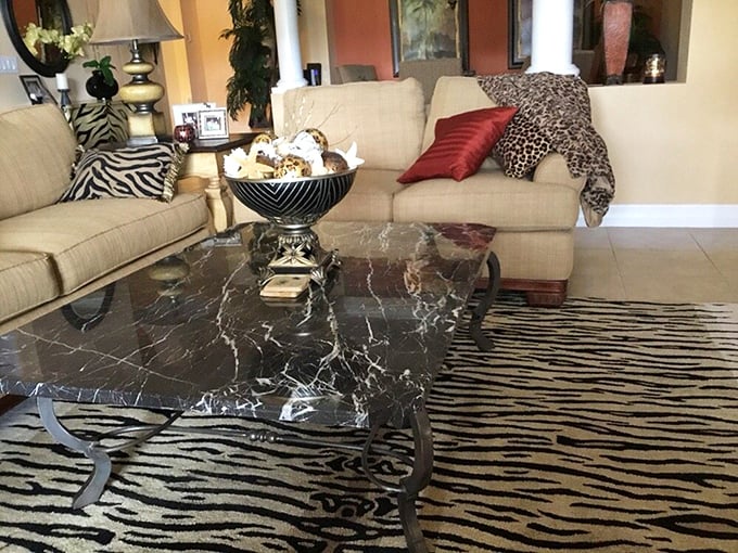 Safari meets sophistication with this marble coffee table and animal print rug combo—proof that secondhand can still be wildly stylish.