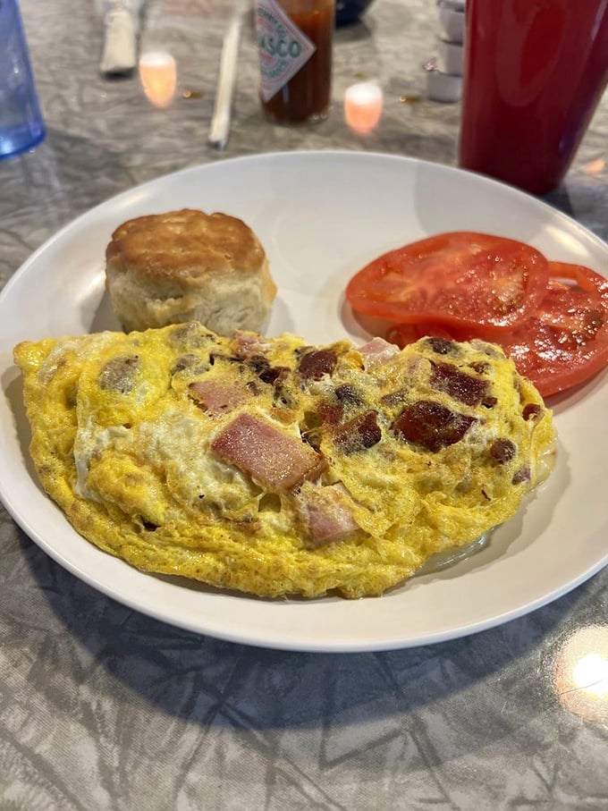 An omelet that doesn't just contain meat – it celebrates it, alongside a biscuit so perfect it deserves its own Instagram account.