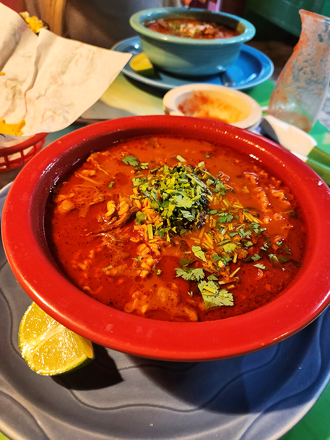 This menudo isn't just soup—it's a spicy, soul-warming tradition in a bowl, garnished with fresh cilantro and a lime wedge that's not just for show.