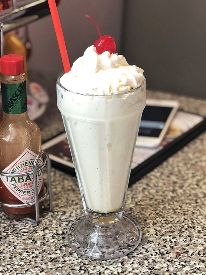 The Orange Creamsicle shake arrives like a dessert ambassador from childhood summers—crowned with whipped cream and a cherry, it's nostalgia in a glass. 