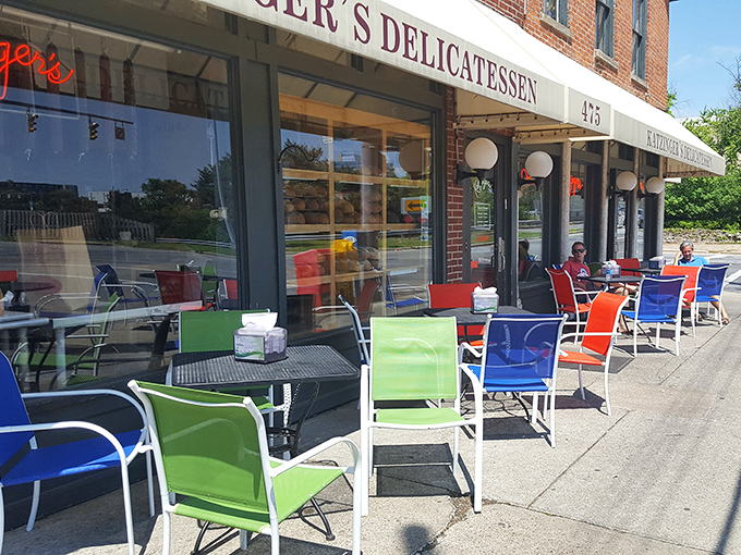 Colorful chairs line the sidewalk, inviting passersby to enjoy their towering sandwiches while watching German Village life unfold.