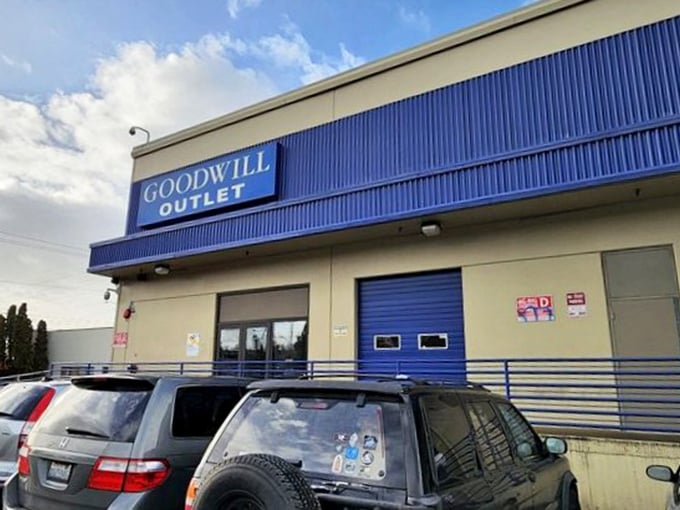 The Goodwill Outlet sign glows against Seattle's characteristically moody sky—a beacon for bargain hunters and sustainability champions alike. 