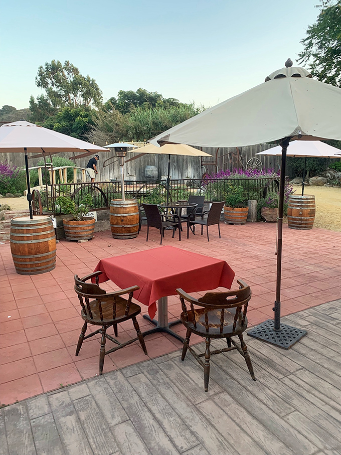 The outdoor seating area—where wine barrels and umbrellas create the perfect California setting for enjoying barbecue masterpieces alfresco.