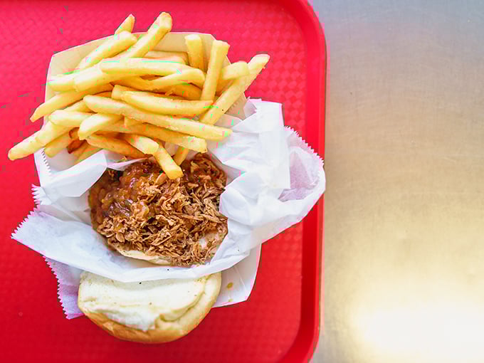 This pulled pork sandwich with golden fries isn't just lunch – it's the reason the phrase "finger-lickin' good" was invented.
