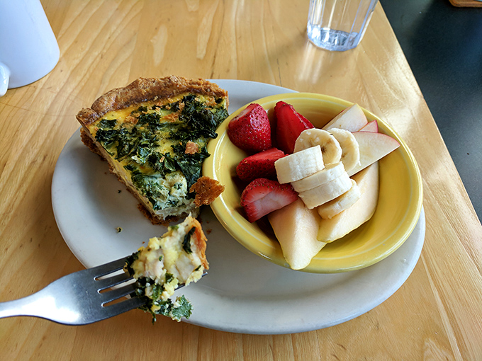 A slice of quiche alongside fresh fruit—the culinary equivalent of business on top, party on the bottom. Sophistication meets joy.