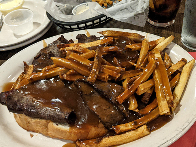 Not just a sandwich but an architectural marvel – open-faced roast beef with gravy-soaked fries that would make a Canadian blush.