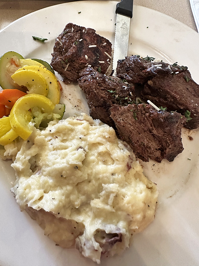 Steak tips that prove sometimes the best things in life aren't whole – charred perfection with mashed potatoes standing by for gravy duty.