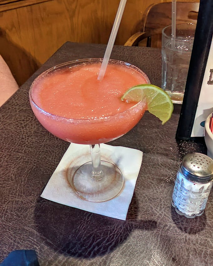 A strawberry margarita with salt-rimmed sophistication—the kind of drink that makes Tuesday feel like Saturday in just one sip.