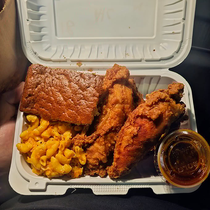 The ultimate to-go package: crispy chicken, mac & cheese, and cornbread—proof that true happiness can indeed fit in a styrofoam container.