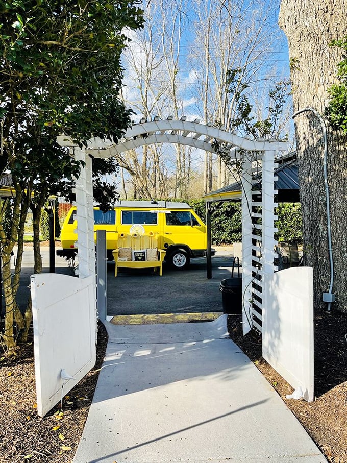 A cheerful yellow van framed by a white garden arch—like the gateway to a Wes Anderson film where everyone eats really, really well.
