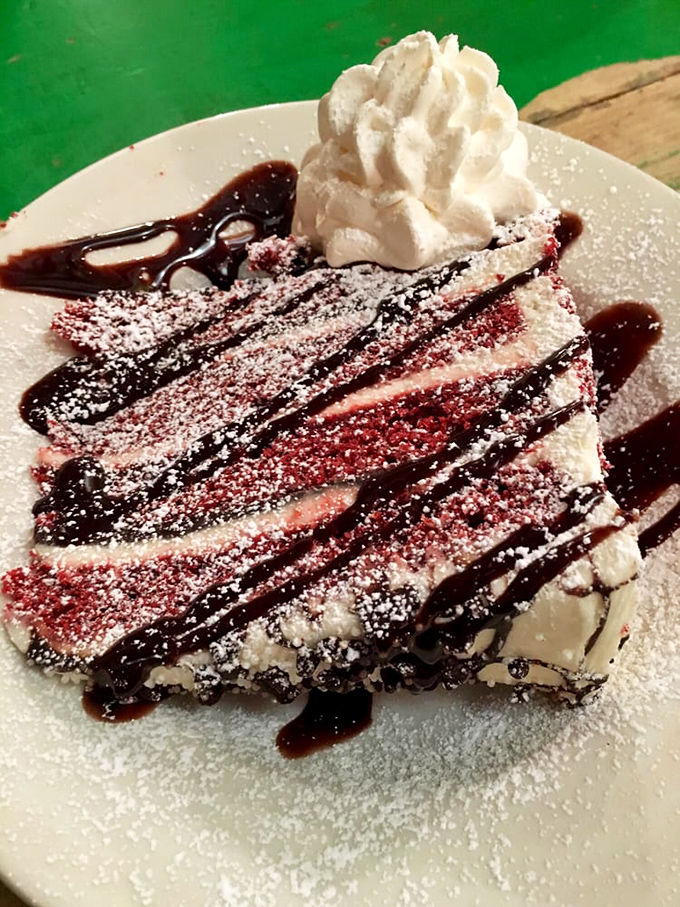 This dessert doesn't whisper sweet nothings—it shouts them, with layers of what appears to be cheesecake drizzled with chocolate and topped with whipped cream.