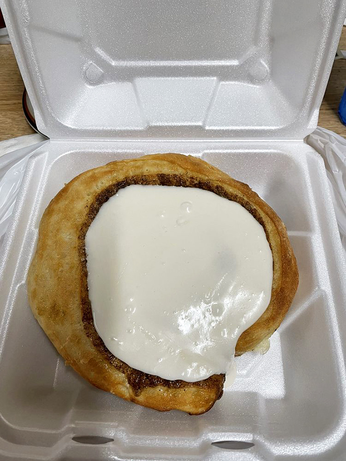 This cinnamon roll in its to-go container isn't just dessert—it's tomorrow's breakfast insurance policy. Future you says "thanks."