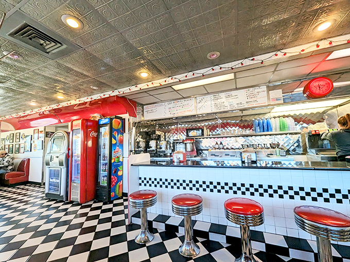 The counter where magic happens—chrome stools, checkered floors, and the promise of comfort food that makes you wonder why you'd ever eat anywhere else.