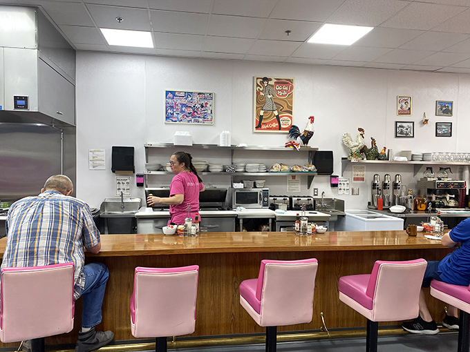 The counter—where solo diners become family and the coffee keeps flowing. Some of life's best conversations happen on pink swivel chairs.