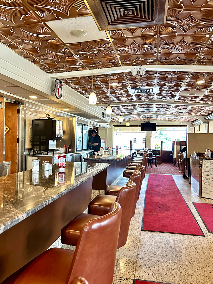 Where the magic happens – copper-tiled ceiling, red carpet runway, and those swiveling counter seats where regulars hold court and servers know your order before you sit down.