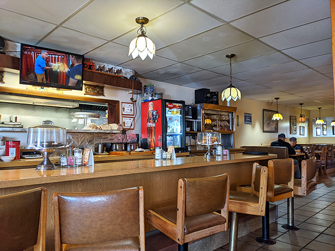 The counter seating—where solo diners become temporary family, watching short-order magic happen while coffee mugs never reach empty.