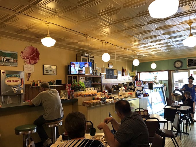 The morning regulars know exactly where to sit – under those pressed tin ceilings, where coffee flows freely and breakfast conversations have no time limit.