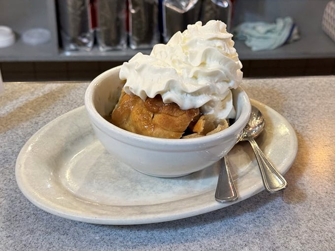 The apple dumpling in its final, most glorious form—crowned with whipped cream and ready to make memories that outlast the meal itself.