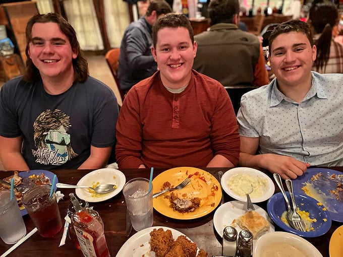 Three smiles that say it all: mission accomplished. The aftermath of a Babe's feast – empty plates, full hearts, can't lose.