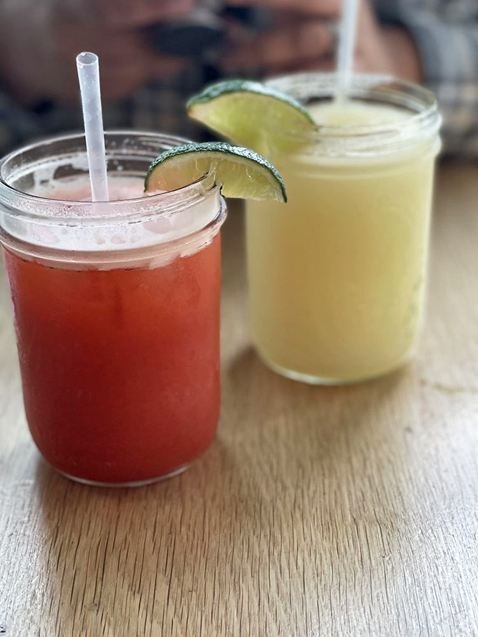 These aren't just beverages—they're liquid refreshment strategically designed to cut through cheese richness. Those lime wedges aren't garnish—they're necessity.