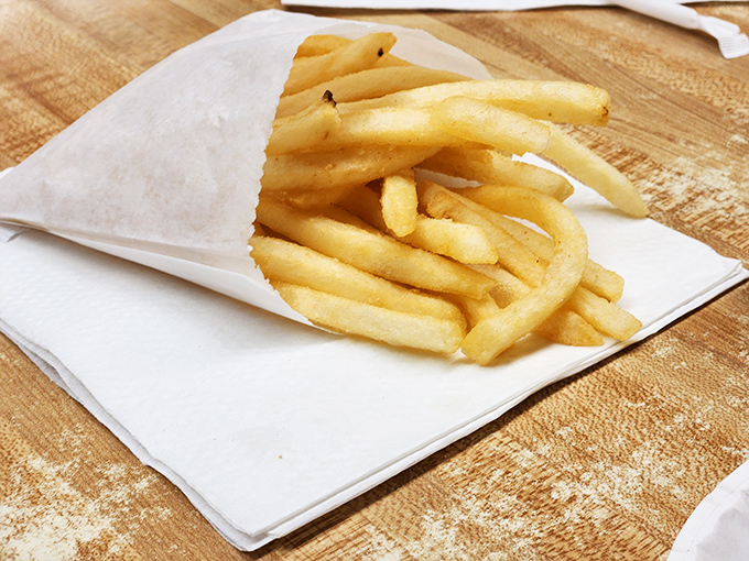 French fries served in paper—simple, unpretentious, and exactly what you want alongside that double cheeseburger and frosty mug of root beer.