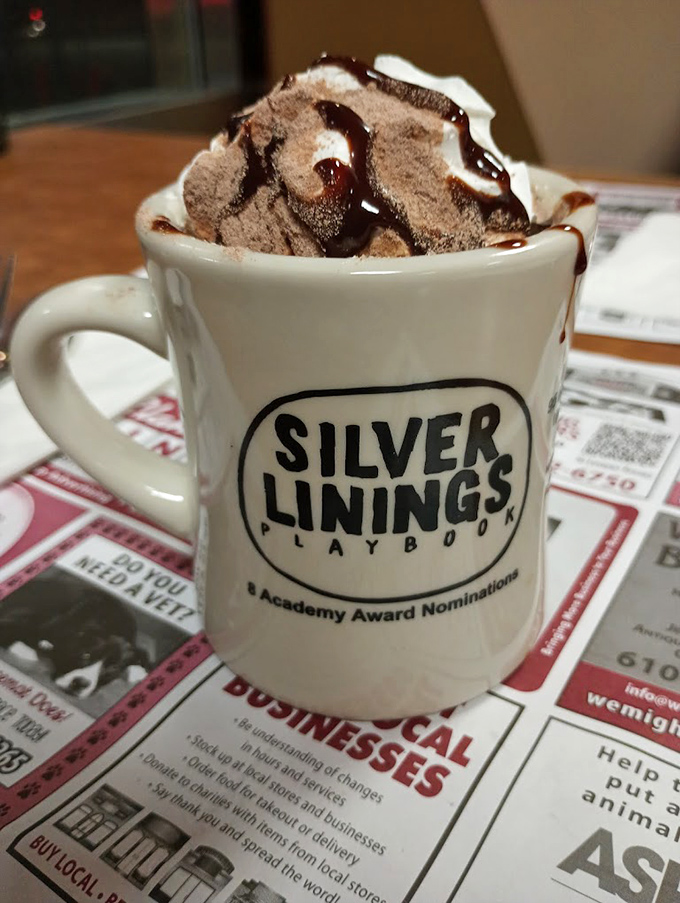 
Hot chocolate served with cinematic flair—the "Silver Linings" mug nodding to the diner's movie fame while whipped cream and chocolate drizzle steal the scene. 