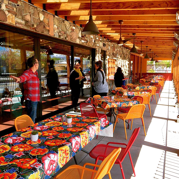 Outdoor seating bathed in sunshine, where colorful tablecloths and stone walls create the perfect backdrop for your inevitable food photos.