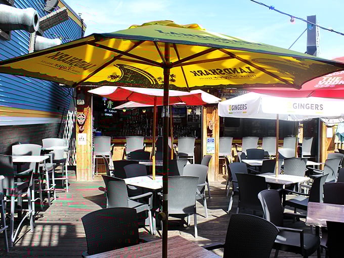 The outdoor deck at Cooper's—where summer dreams come true under yellow umbrellas and the lighthouse keeps watch over your seafood feast.