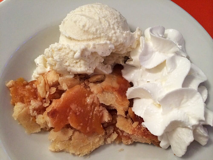 Not just dessert—it's an edible hug. This peach pie with ice cream and whipped cream is why elastic waistbands were invented.