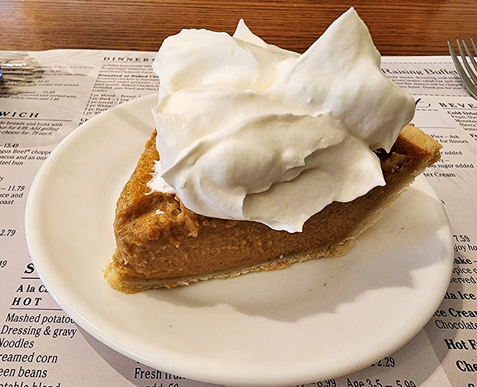 Pumpkin pie crowned with a cloud-like puff of real whipped cream – the grand finale that somehow makes you forget you just promised yourself you couldn't eat another bite.