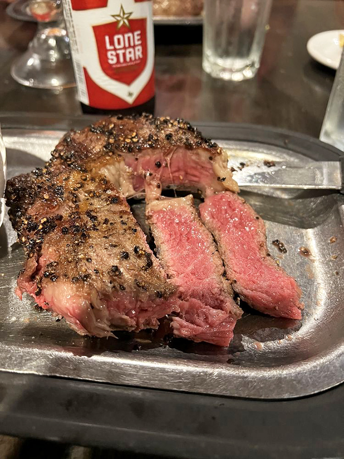A perfectly cooked ribeye with a peppercorn crust that doesn't need fancy garnishes—just a cold Lone Star and your undivided attention.