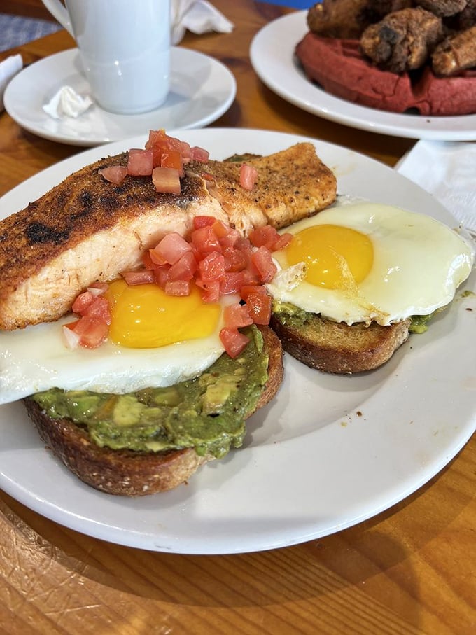 Avocado toast gets the royal treatment with perfectly cooked salmon and sunny-side-up eggs—proof that trendy can also be transcendent.
