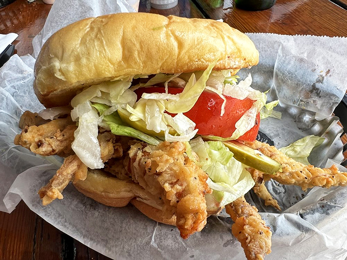A soft shell crab sandwich that's practically bursting from its bun—proof that sometimes the best seafood experiences come between two pieces of bread.