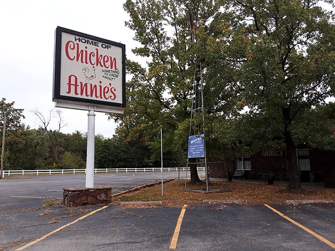 The roadside sign stands as a beacon of hope for hungry travelers – "Home of Chicken Annie's" means salvation is just a turn away.