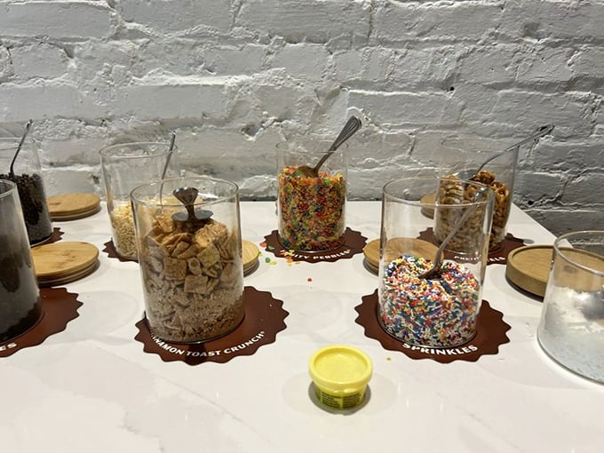 The topping bar offers crunchy, colorful customization options – because the only thing better than chocolate is chocolate wearing sprinkles and cookie bits.