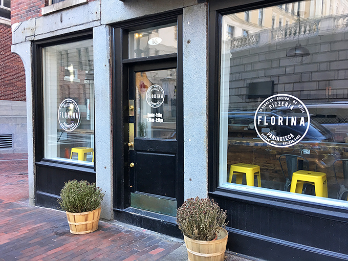 Florina's storefront welcomes you with those cheerful yellow stools visible through the window – pizza paradise awaits behind that humble door!