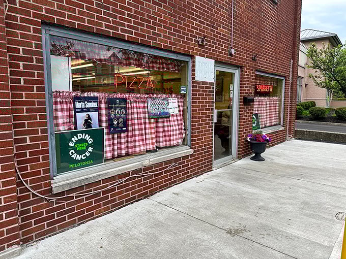 Rubino's classic red-checkered curtains and neon "PIZZA" sign – like stepping into a delicious time machine where calories don't count.