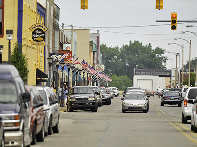 Bay City's main street: "American flags flutter above a street where your Social Security check stretches like saltwater taffy. Small-town charm with big-time savings!"