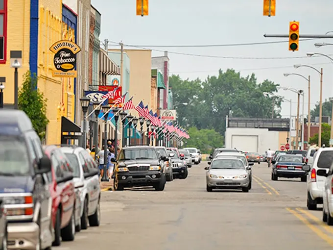 Bay City's main street: "American flags flutter above a street where your Social Security check stretches like saltwater taffy. Small-town charm with big-time savings!"