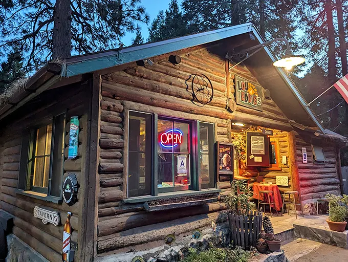 As twilight falls, LouEddie's cabin glows like a pizza beacon in the forest. That "OPEN" sign might as well say "HEAVEN."