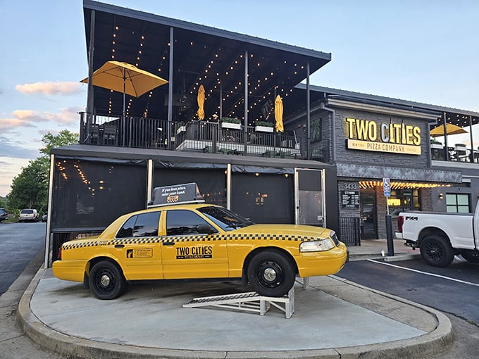 That yellow taxi isn't lost—it's Two Cities' cheeky nod to their New York-Chicago pizza rivalry. The rooftop dining awaits!