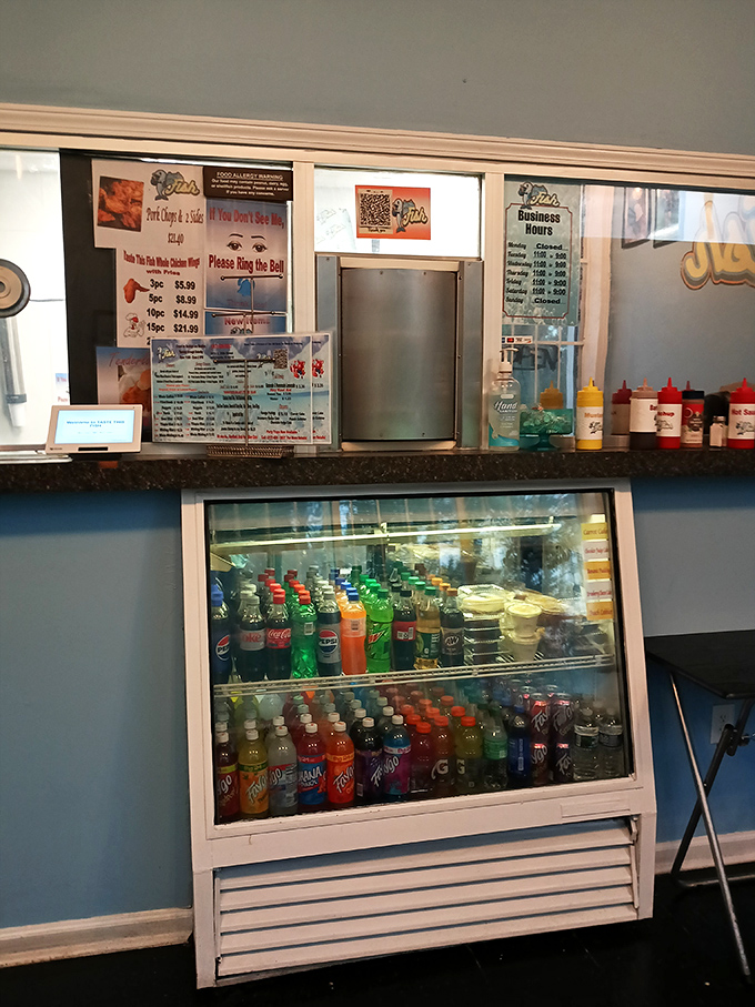 No fancy digital displays here—just a straightforward menu, colorful soda selection, and condiments standing at attention, ready for duty.