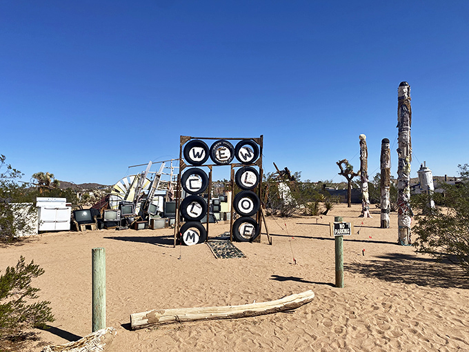 The welcome sign says it all—this isn't your grandmother's art gallery. Tires repurposed as letters create a greeting as warm as the desert sun.