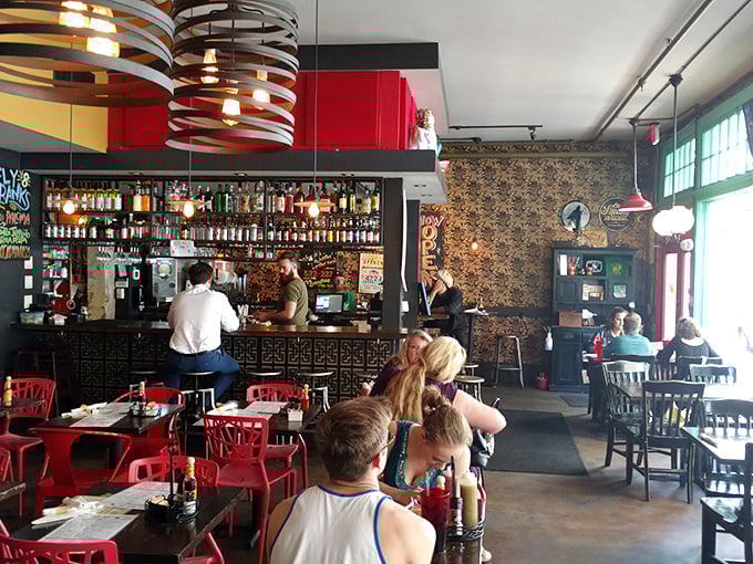 Step inside and the vibrant red chairs pop against eclectic décor, creating that perfect sweet spot between "cool hangout" and "I need to Instagram this immediately."