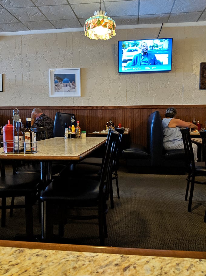 Inside, stained glass pendant lights cast a warm glow over wood-paneled walls, creating that perfect "been-here-forever" diner atmosphere that chain restaurants try to replicate.